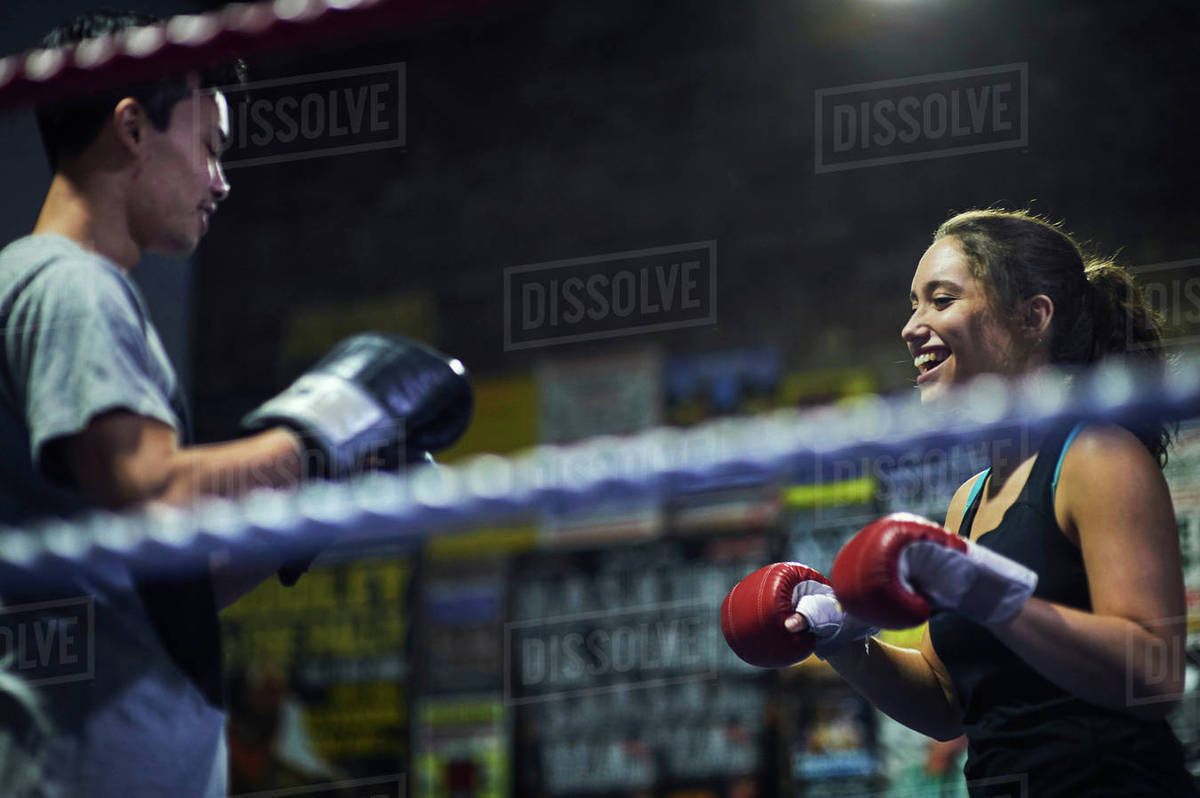 Male and female boxers having boxing match in ring - Stock Photo - Dissolve