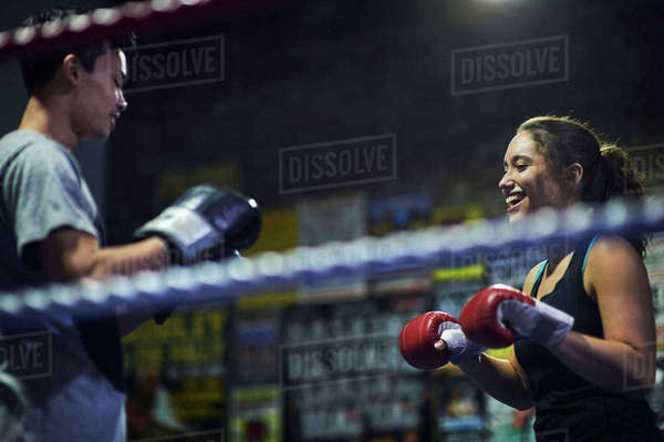 Male and female boxers having boxing match in ring - Stock Photo - Dissolve