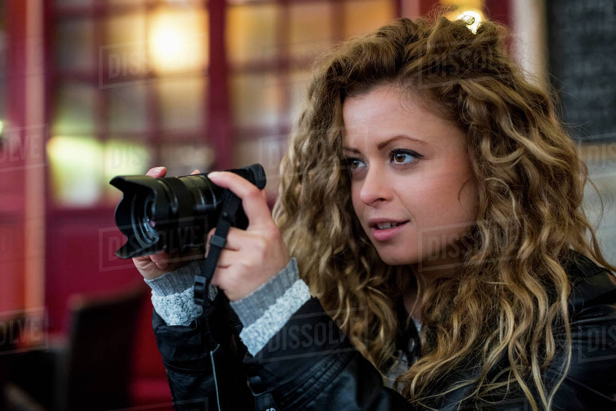 Woman using digital camera - Stock Photo - Dissolve