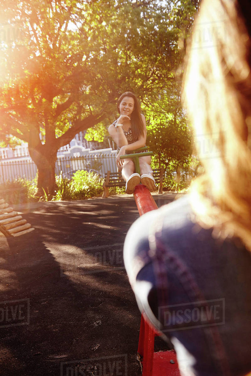 Two female friends at park, fooling around on see-saw - Royalty-free ...