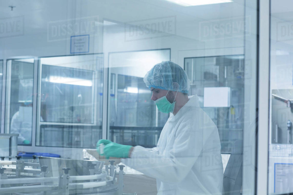 Worker packaging products in pharmaceutical plant - Stock Photo - Dissolve