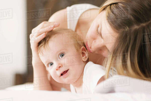 Mother and baby bonding on bed - Royalty-free Stock Photo | Dissolve