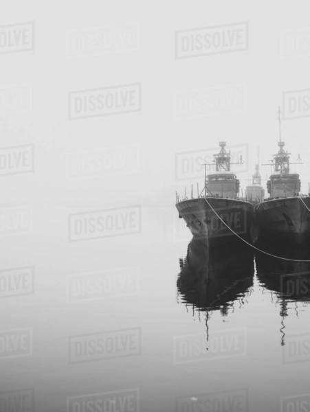 Ships docked in still harbor - Stock Photo - Dissolve