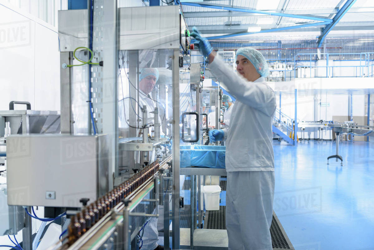 Worker on packing line in pharmaceutical factory - Stock Photo - Dissolve