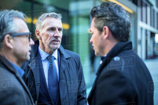 Businessmen in street talking - Stock Photo - Dissolve