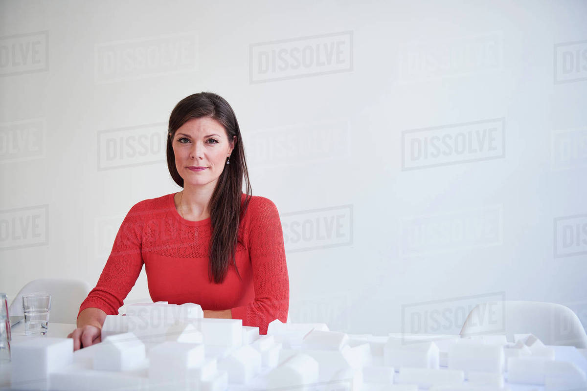 Portrait of architect with architectural model looking at camera ...