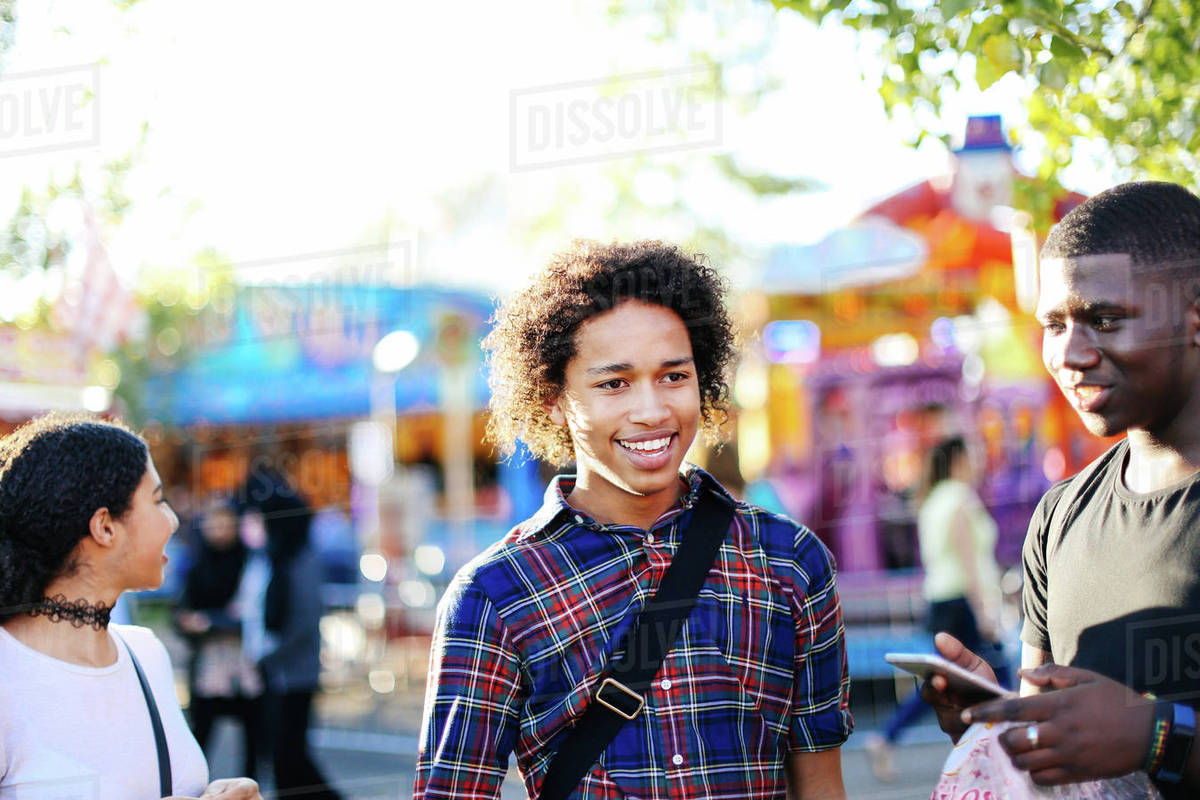 Group of friends at funfair, smiling - Stock Photo - Dissolve