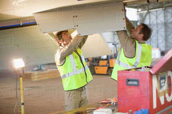 Aircraft workers checking airplane - Royalty-free Stock Photo | Dissolve