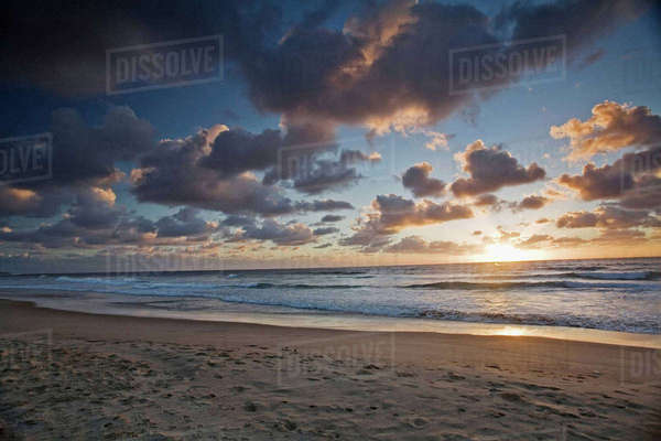 Sun setting over tropical beach - Royalty-free Stock Photo | Dissolve