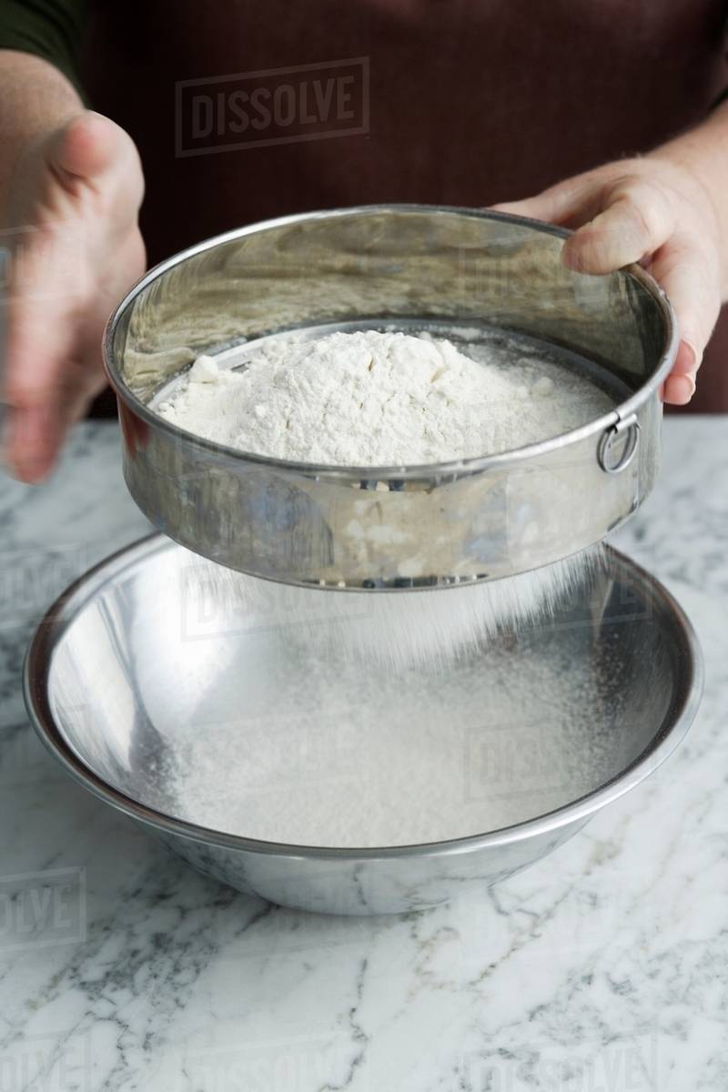 Chef sifting flour in bowl - Royalty-free Stock Photo | Dissolve