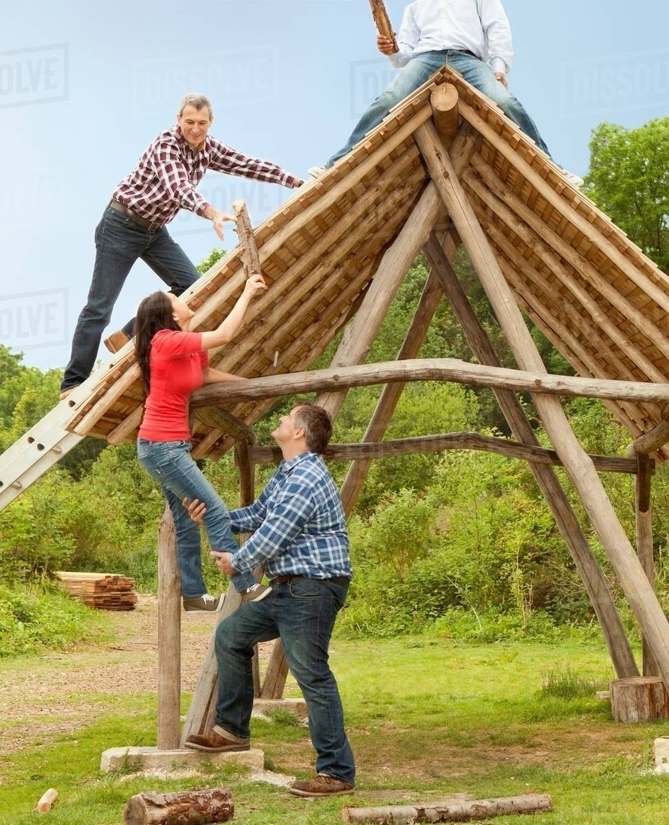 People building log hut together - Royalty-free Stock Photo | Dissolve