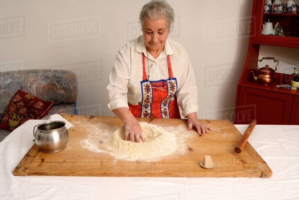 Older woman baking in living room - Stock Photo - Dissolve