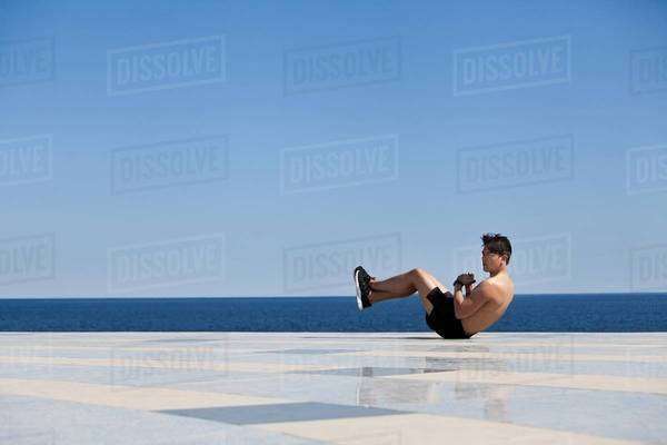 Athlete doing sit-ups on tiled surface - Royalty-free Stock Photo ...