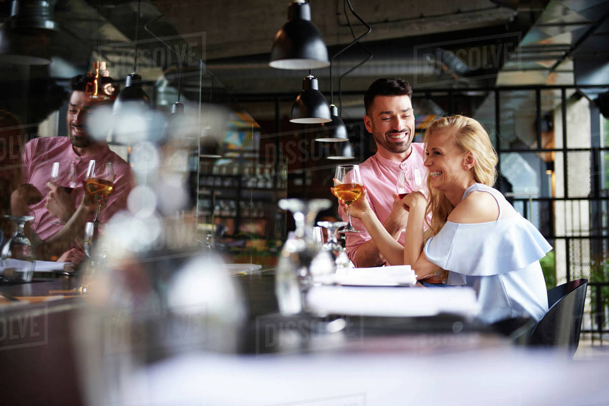 Couple laughing together at restaurant table - Stock Photo - Dissolve