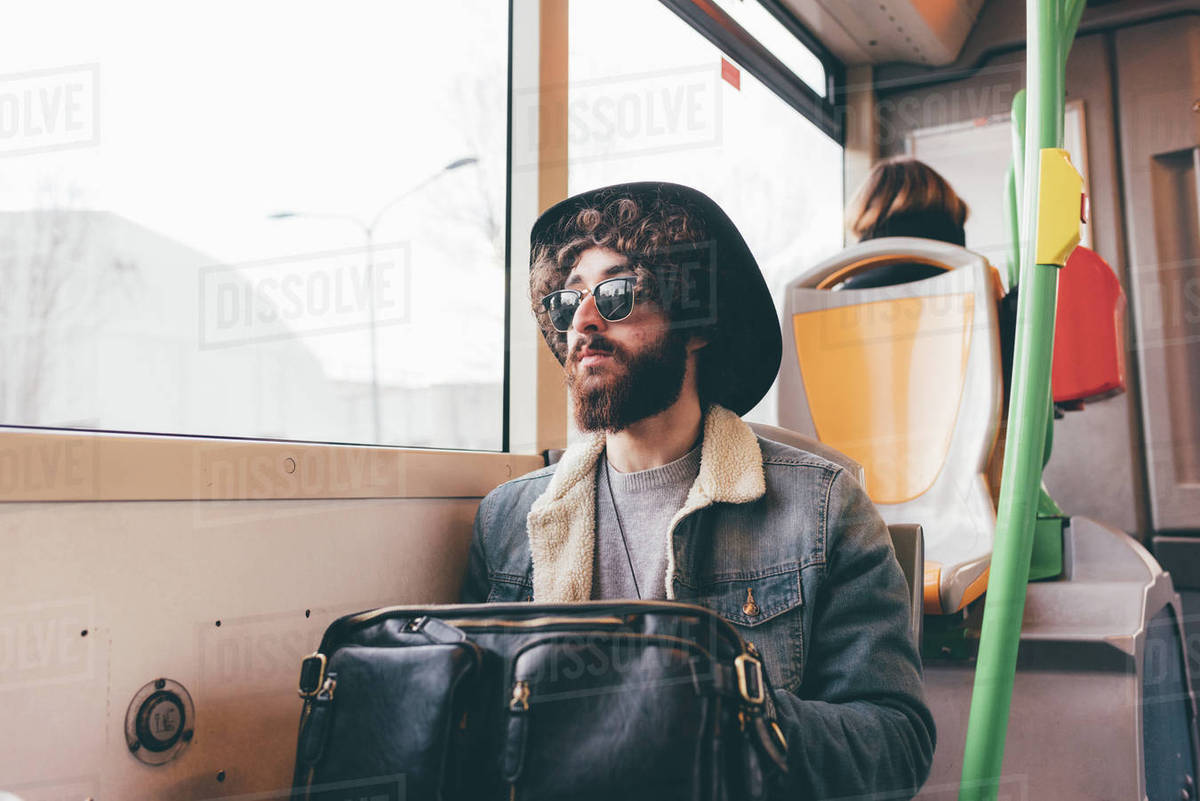 Young man sitting on subway train - Stock Photo - Dissolve