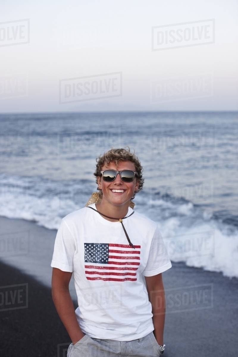 Smiling boy standing on beach - Stock Photo - Dissolve