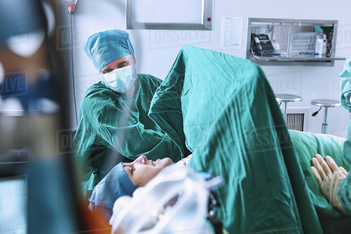 Surgeons preparing patient for surgery in maternity ward operating ...