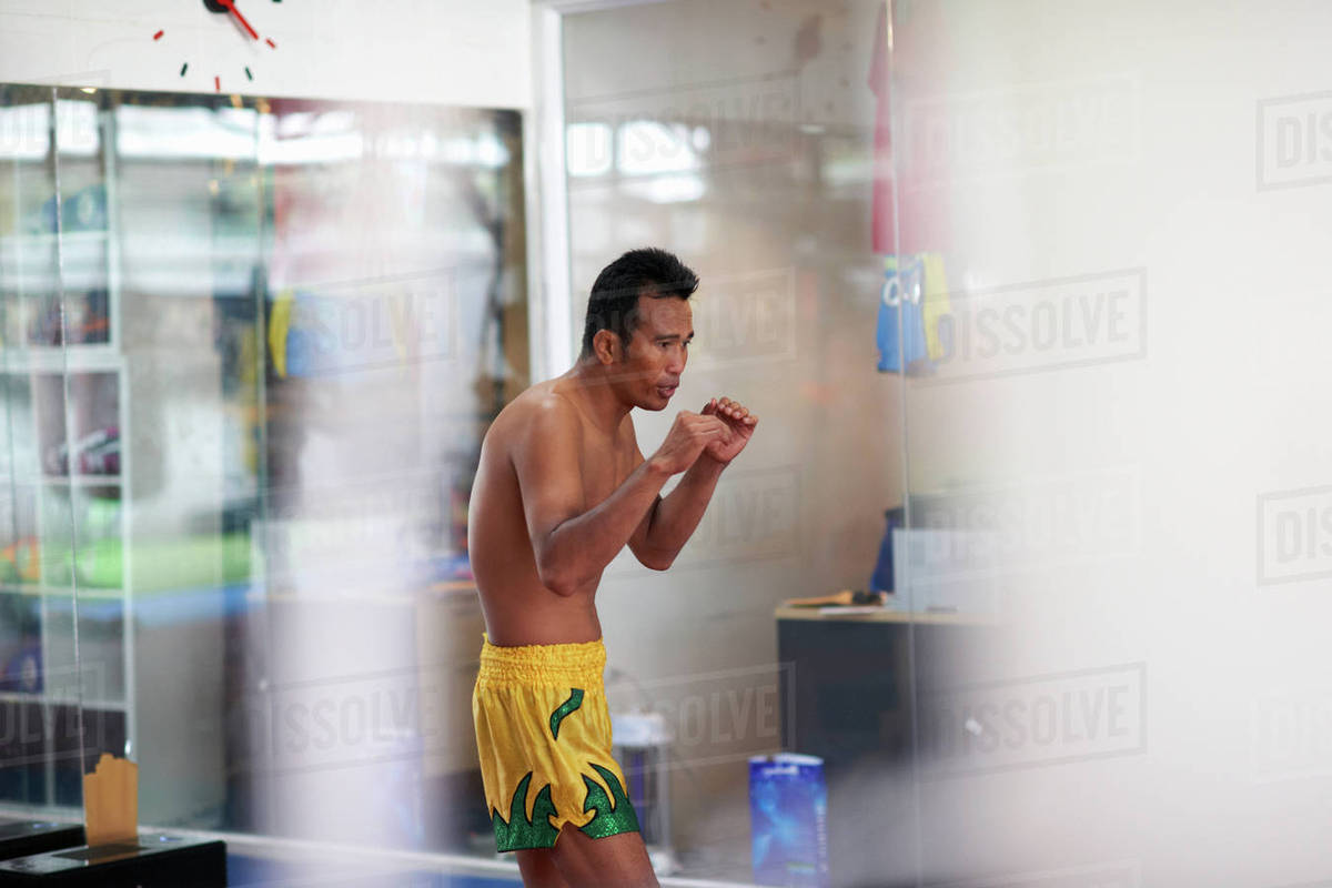Mid adult male boxer practicing in gym - Stock Photo - Dissolve