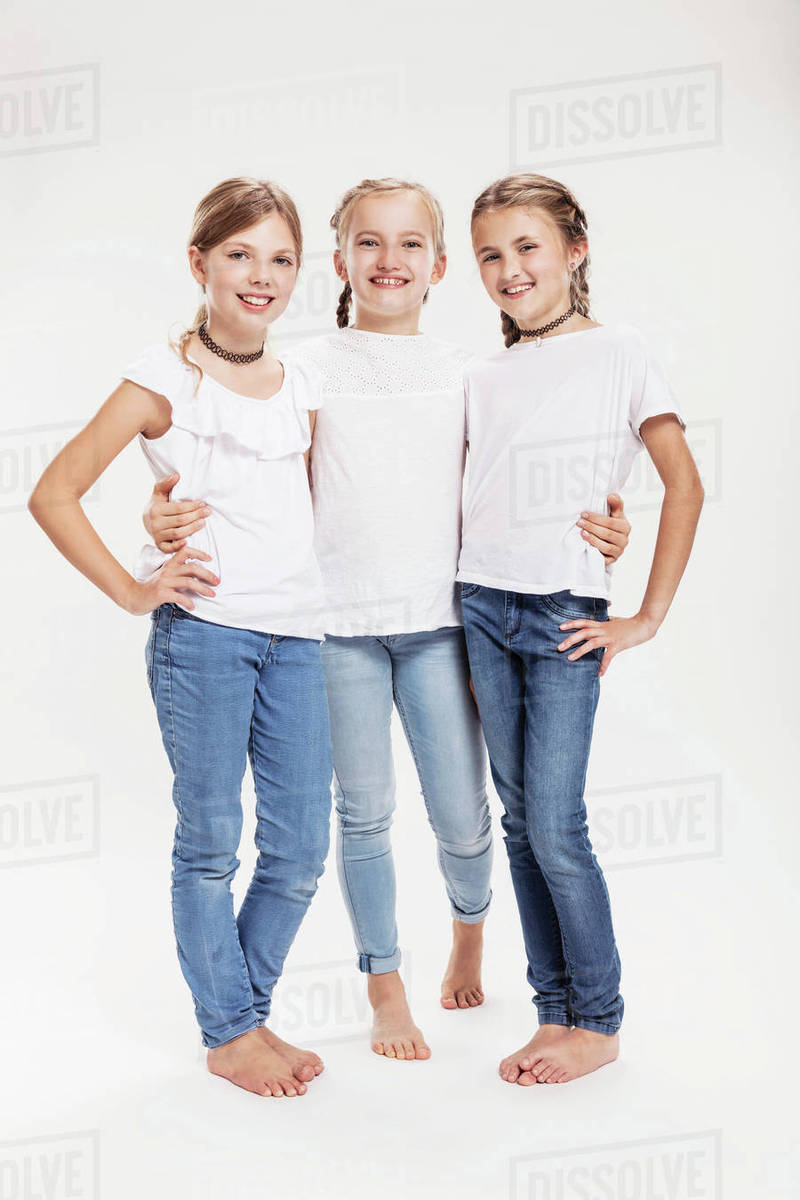 Studio portrait of three girls posing with hands on hips - Stock Photo ...