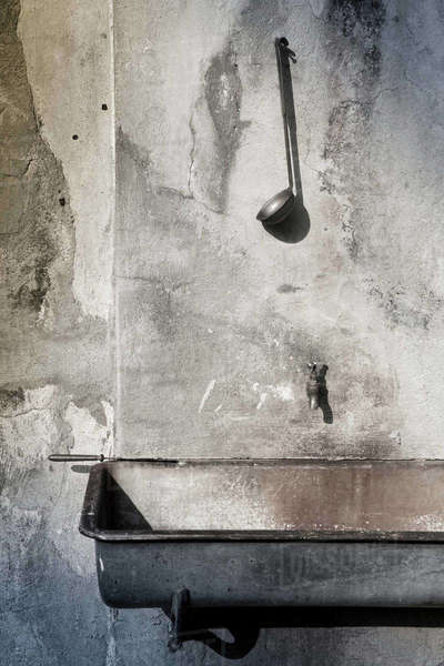 Wall trough and tap with ladle - Stock Photo - Dissolve