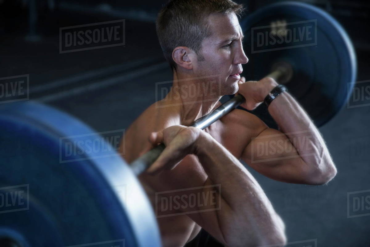 Man exercising in gym, using barbell, front squat position - Stock ...