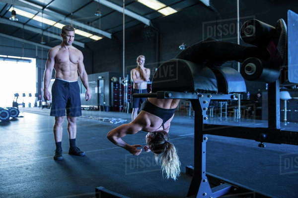 Three people exercising in gymnasium, using equipment - Royalty-free ...