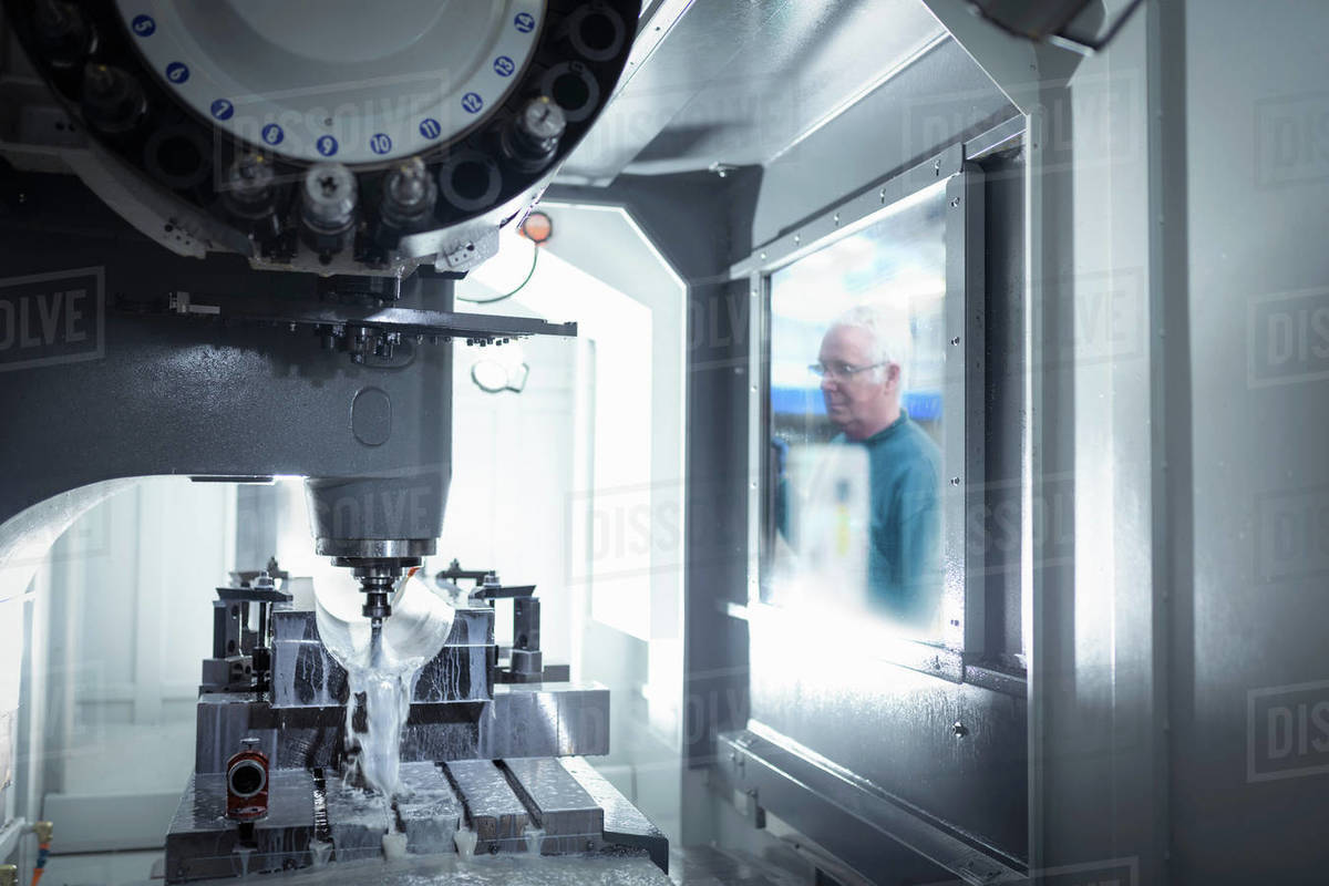 Engineer operating milling machine in precision engineering factory ...