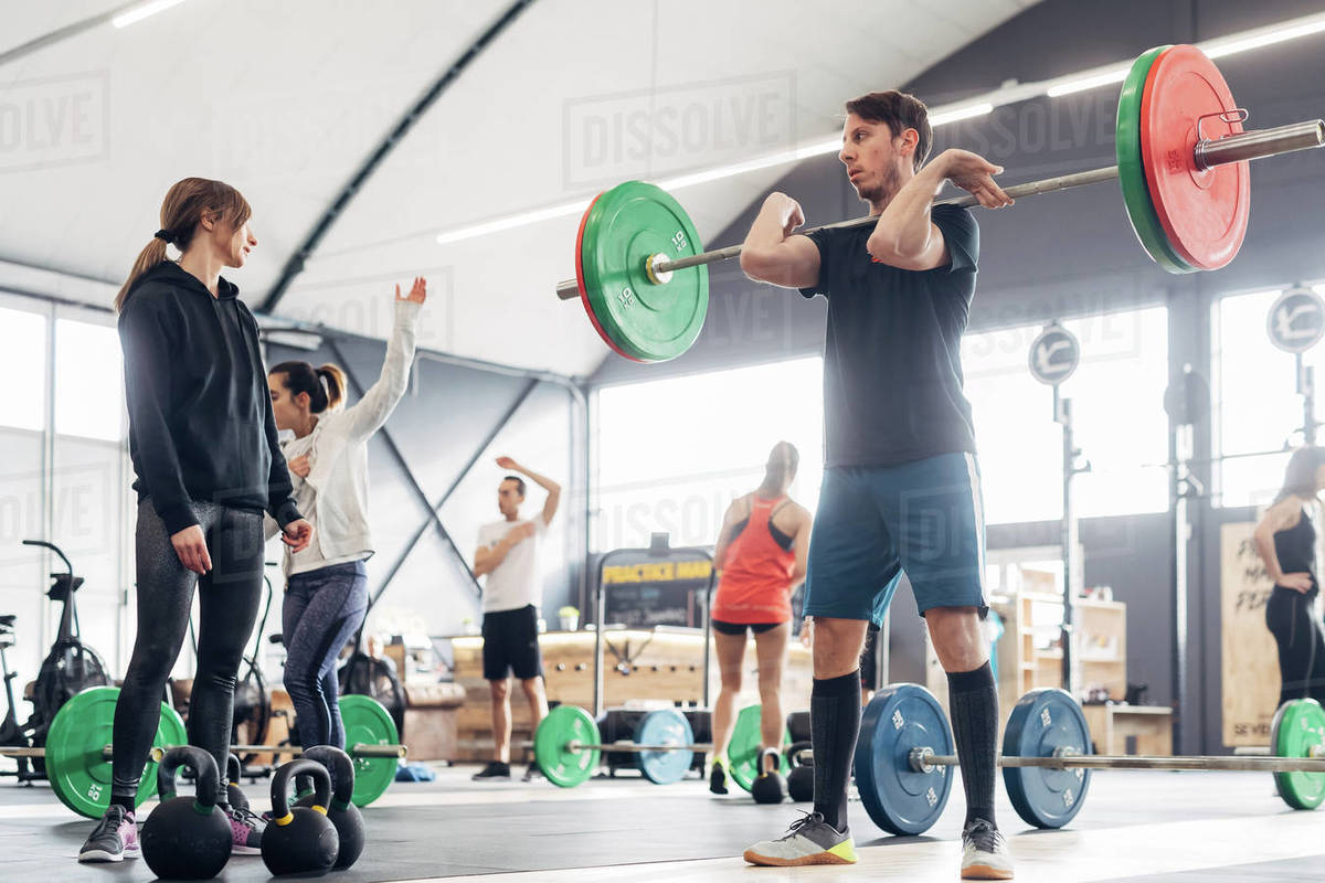 People in gym weightlifting - Stock Photo - Dissolve