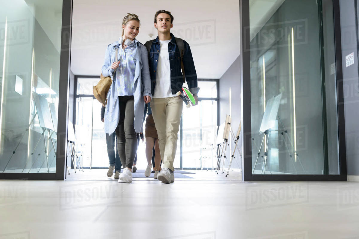 Students entering college building by glass doors - Stock Photo - Dissolve