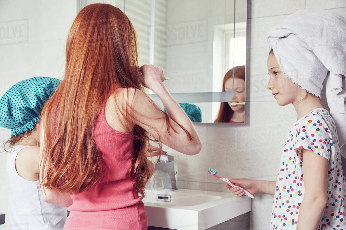 Girls brushing teeth - Stock Photo - Dissolve