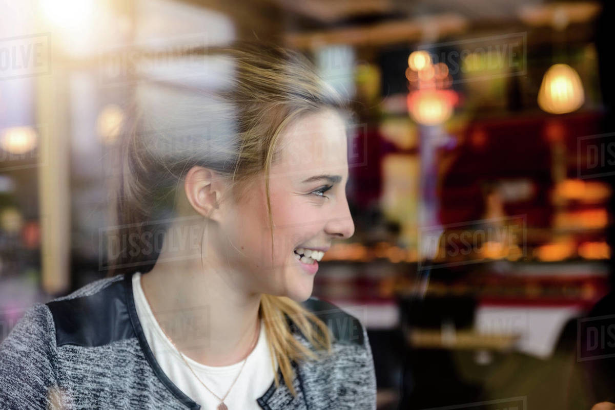 Young woman in cafe window seat, view through window - Stock Photo ...