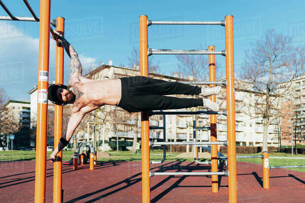 Man using horizontal ladder in outdoor gym - Royalty-free Stock Photo ...