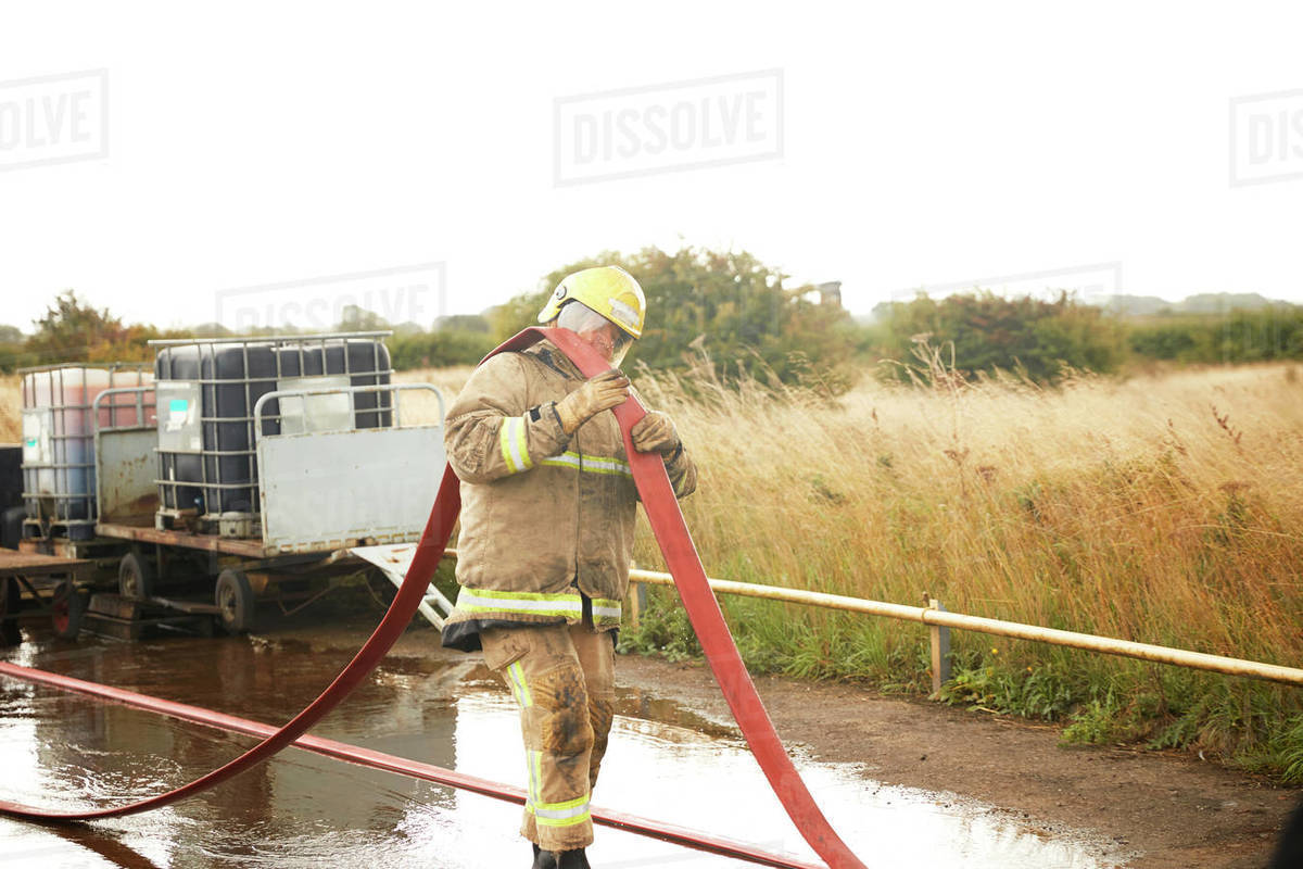 Firemen training, fireman carrying fire hose over his shoulder at ...
