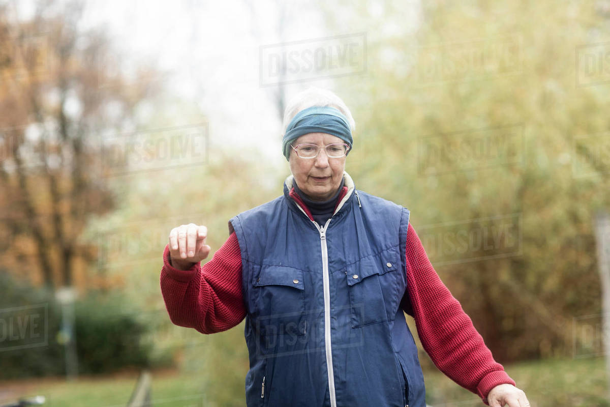 Senior woman walking in park - Stock Photo - Dissolve