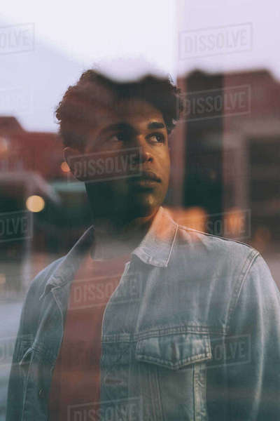 Reflection of man and buildings in glass window - Stock Photo - Dissolve