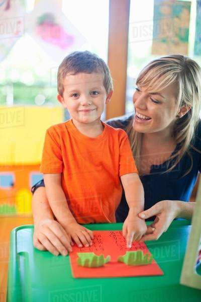 Portrait of boy and teacher counting at nursery school - Stock Photo ...