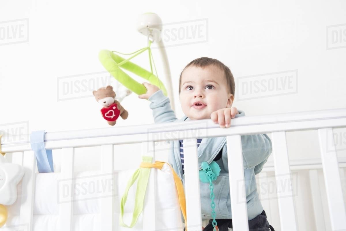 Alert baby boy gazing out from crib - Royalty-free Stock Photo | Dissolve
