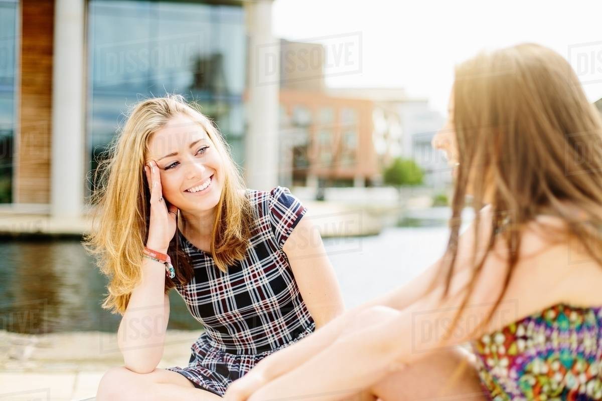 Friends chatting by canal - Royalty-free Stock Photo | Dissolve