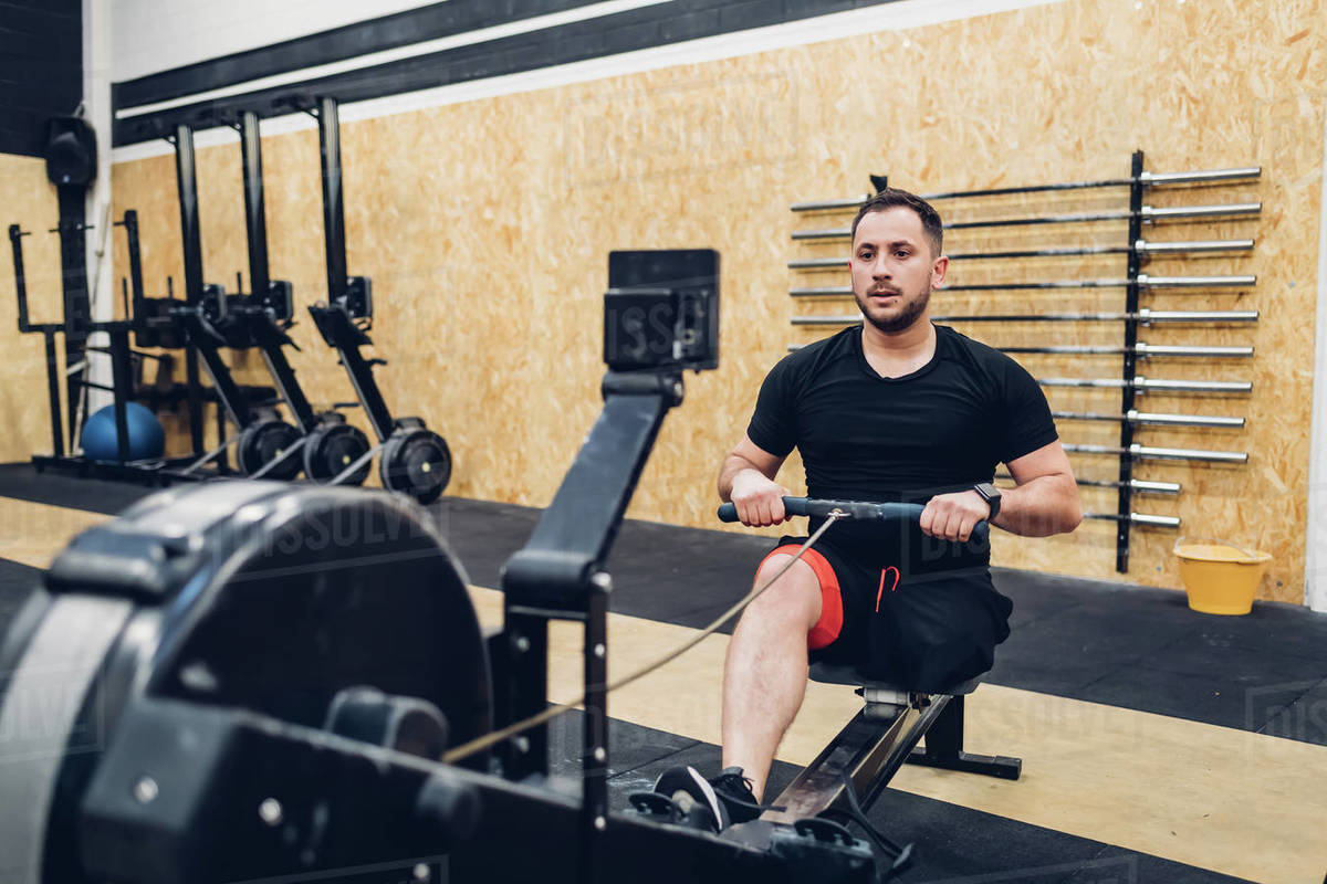 Man with disability using rowing machine in gym - Royalty-free Stock ...