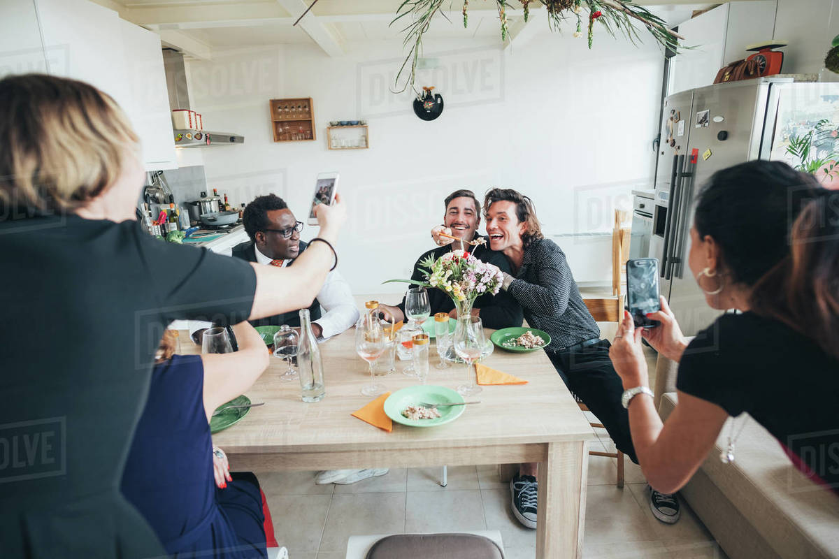 Businessmen and businesswomen celebrating at lunch party in loft office ...