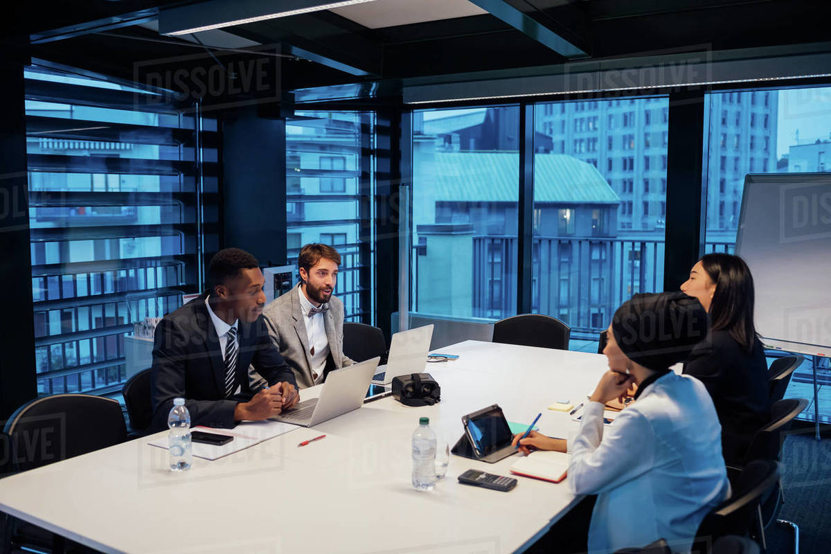 Businessmen and women having discussion over conference table meeting ...