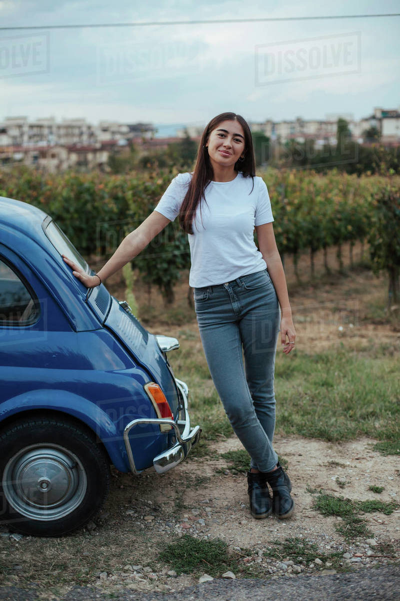 Portrait of woman leaning against car in countryside, Florence, Toscana ...