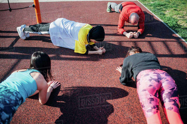 Calisthenics class at outdoor gym, young women and man practicing yoga ...