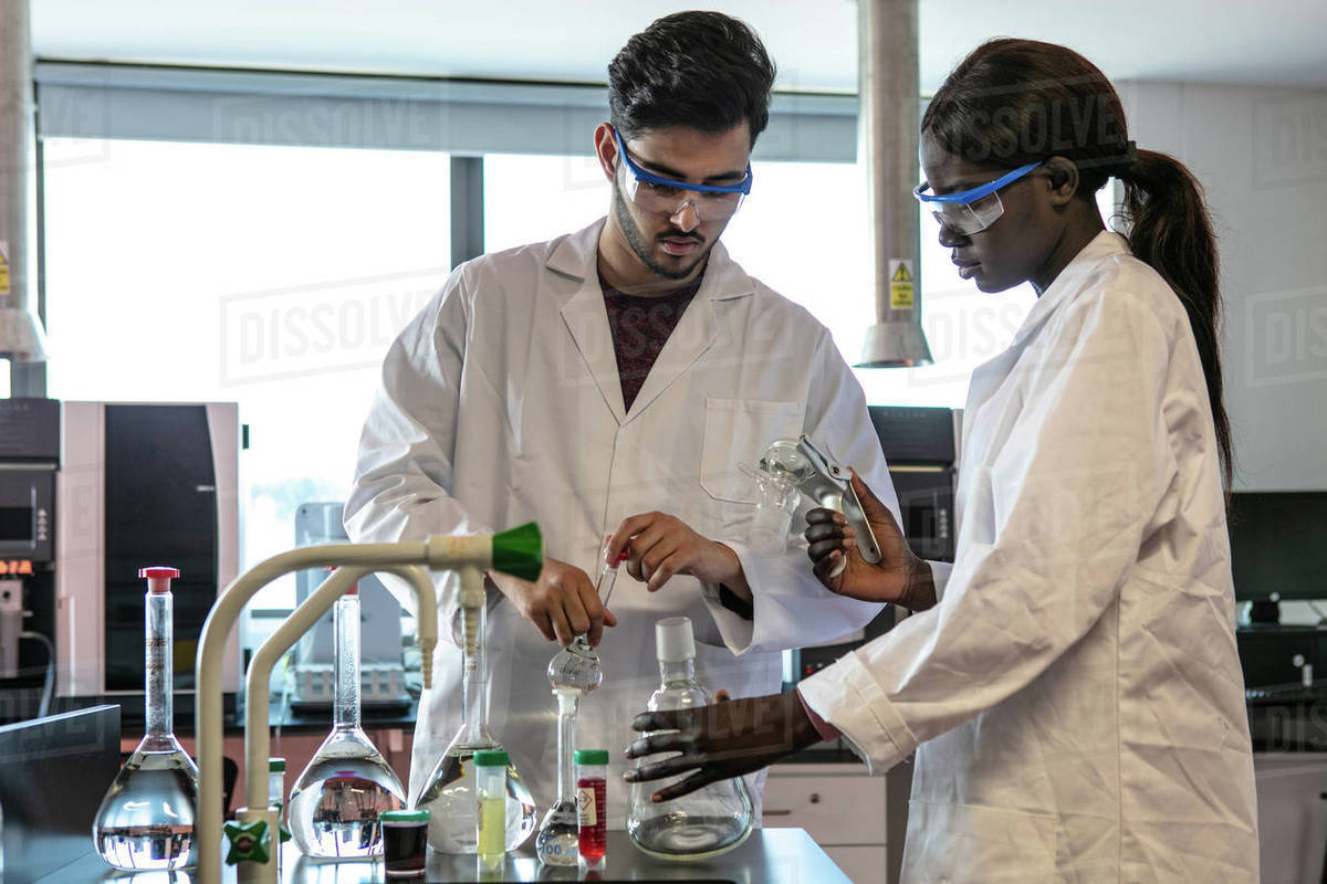 Young male and female scientists preparing experiment with sample ...