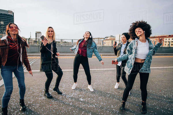 Friends dancing in street to smartphone music, Milan, Italy - Royalty ...