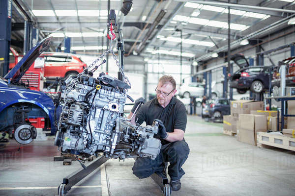 Engineer with car engine in car service centre - Stock Photo - Dissolve