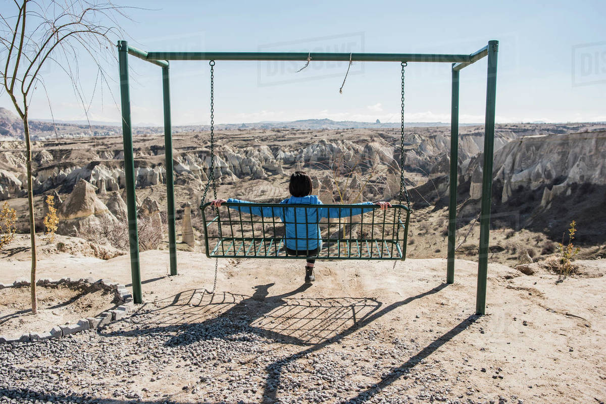 Woman enjoying view of fairy chimney valley on swing, Göreme ...