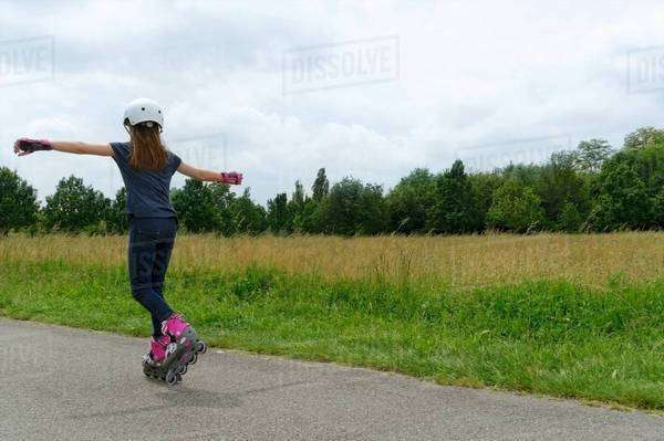 Rear view of girl rollerblading in park - Royalty-free Stock Photo ...