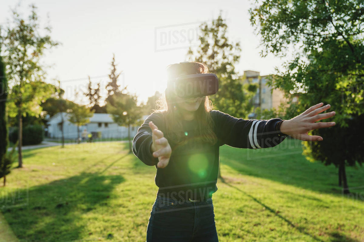 Young woman looking through VR headset in park - Royalty-free Stock ...