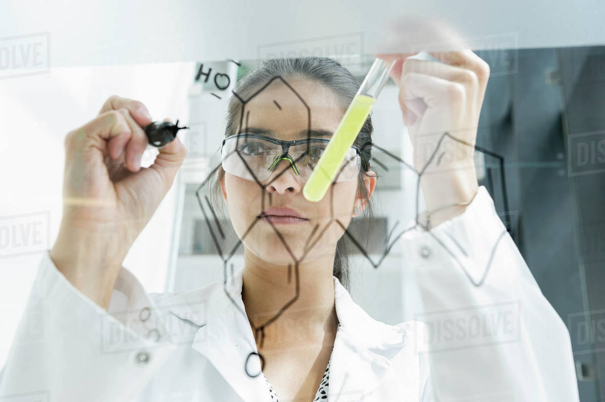 Medical student drawing atoms on glass wall in classroom - Stock Photo ...